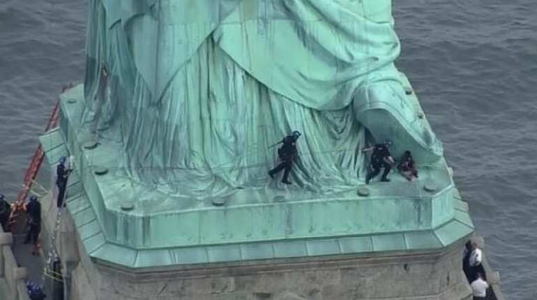 Watch: Woman tries to scale Statue of Liberty to protest against Trump ...